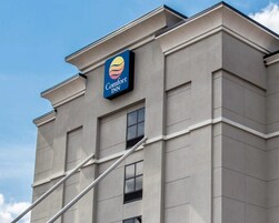 Um edifício com a placa Comfort Inn, apresentando um logo estilizado do sol e da lua.