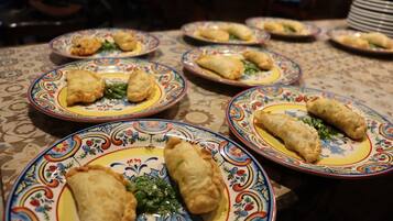 Uma mesa com pratos de pastelaria e uma pilha de pratos ao fundo.