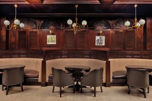 Um quarto com um espaço de estar com um banco curvo, uma mesa redonda e quatro cadeiras.
