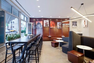 Um restaurante moderno com um balcão extenso, diversas áreas de estar e obras de arte nas paredes.