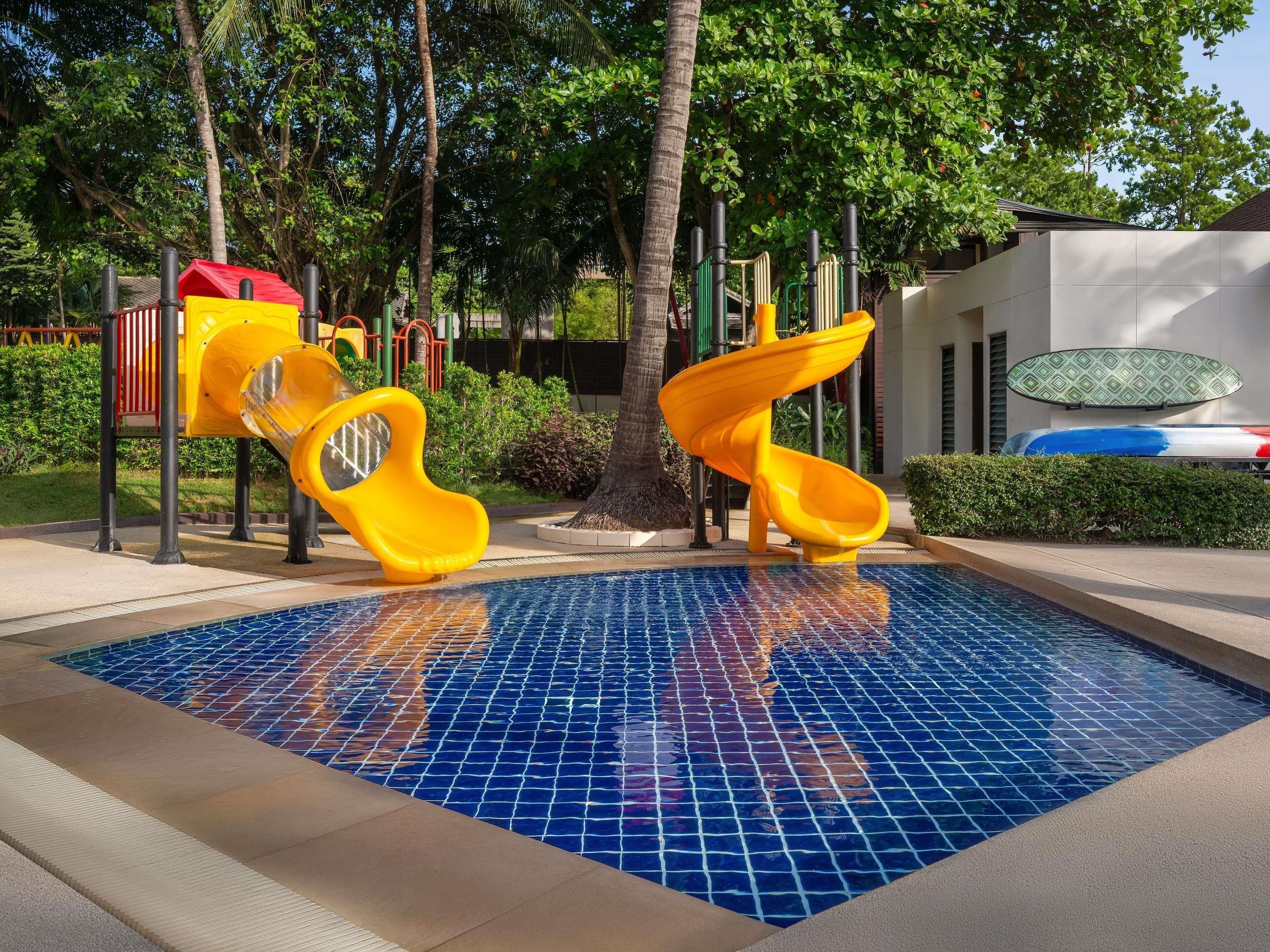 Uma área de recreação infantil com escorregadores e piscina.