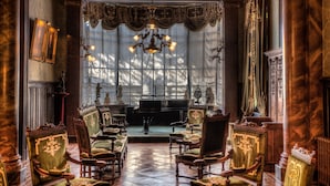 Uma sala imponente com mobiliário requintado, um piano de cauda e uma grande janela com cortinas elaboradas.