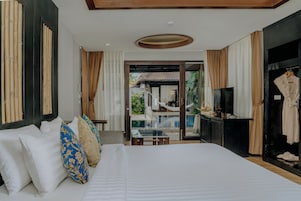 Quarto de hotel com cama grande, televisão e vista para piscina e área externa.