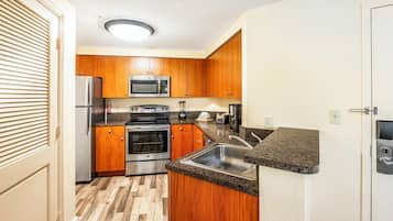 Um frigorífico/congelador grande, um micro-ondas, uma placa de cozinha