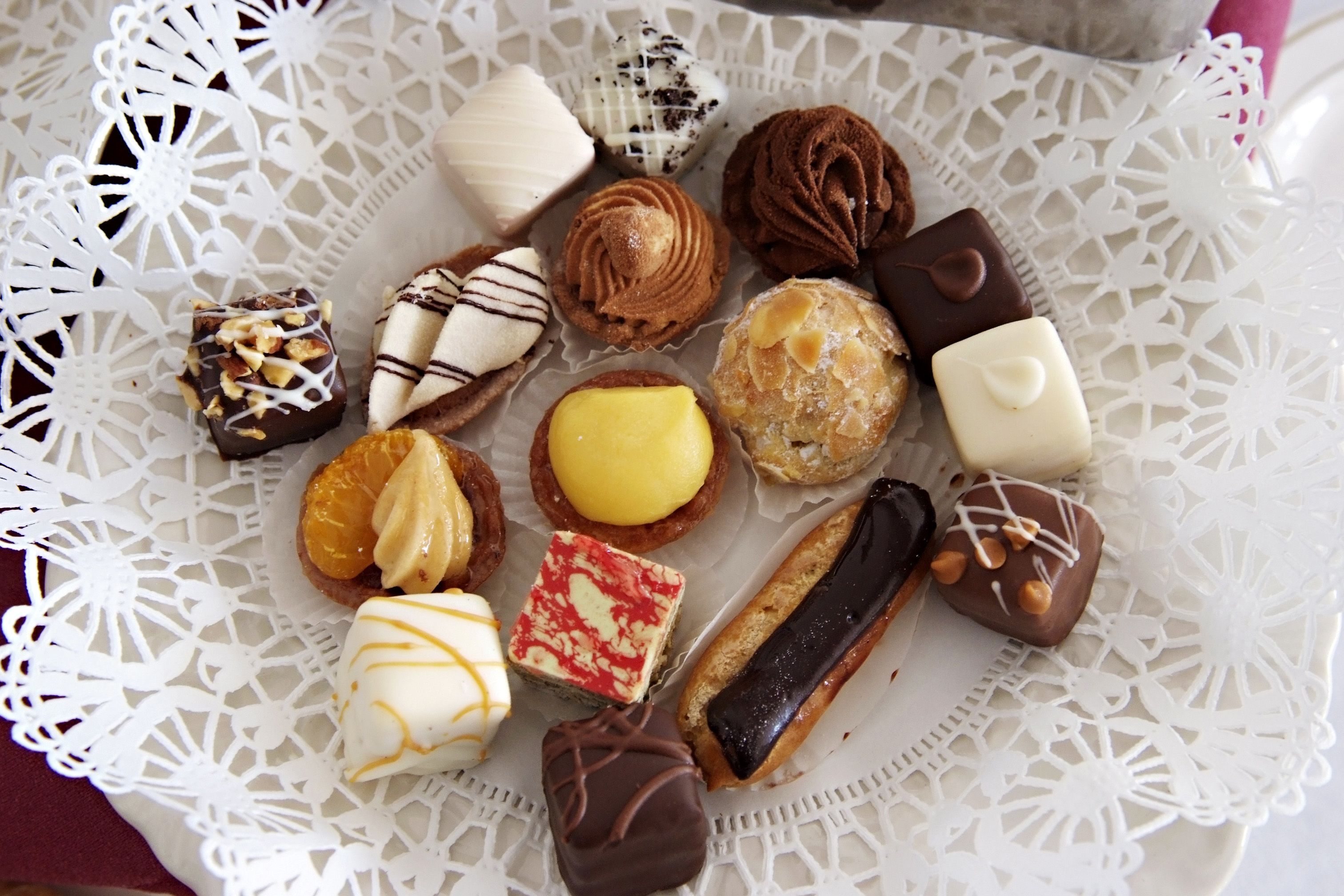 Diversos doces sobre um rendado.