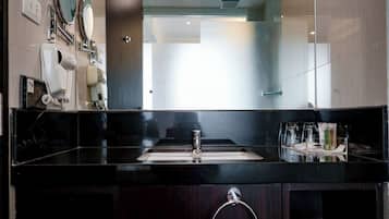 Uma casa de banho moderna com bancada preta, pia e espelho.