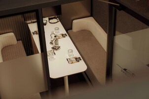 Uma sala de conferências com uma mesa comprida, várias cadeiras e folhetos informativos.