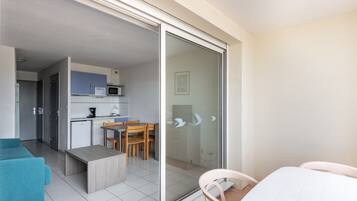 Um apartamento moderno com cozinha, sala de jantar e varanda com porta de vidro deslizante.