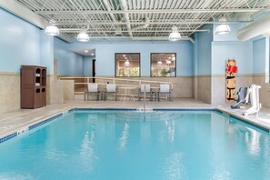 Piscina interna com área de bar, assentos e posto de salva-vidas.