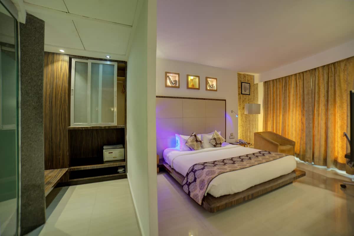 Um quarto moderno com uma cama grande, cabeceira de madeira, mesa de cabeceira e guarda-roupa.