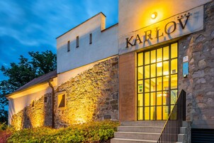 Um edifício com fachada de pedra e uma grande entrada de vidro com a inscrição