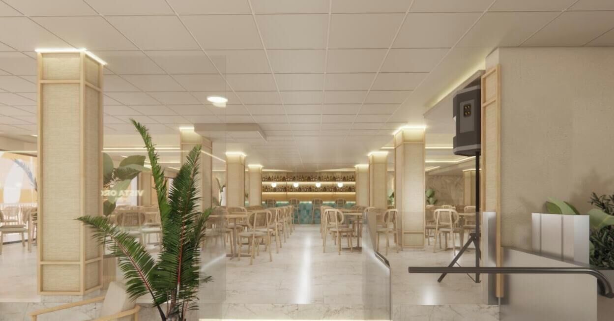 Um lobby de hotel com uma área de estar central, uma mesa de recepção e uma escadaria.