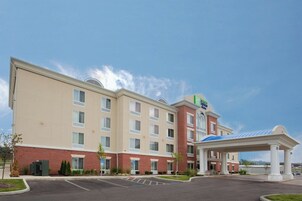 Um hotel com vários andares, fachada plana, área de estacionamento coberta e céu claro.