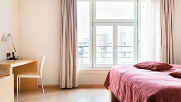 Quarto com cama, escrivaninha e cadeira.
