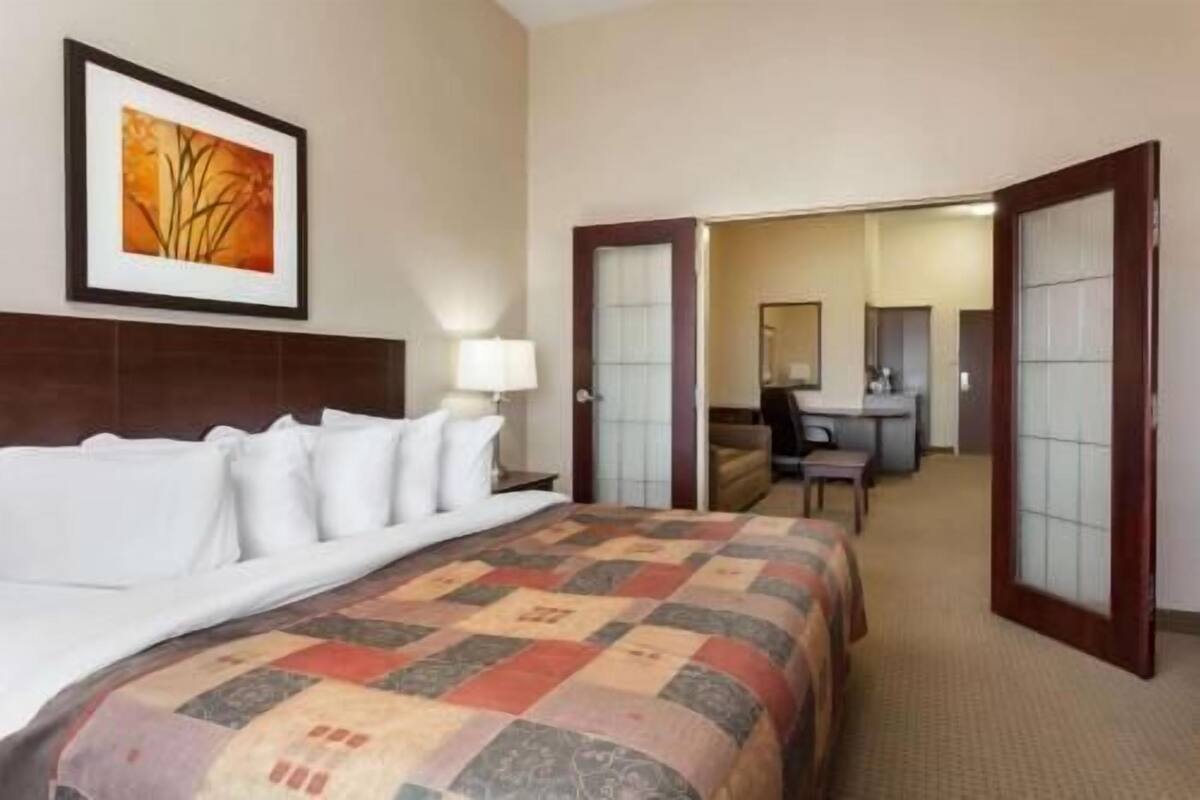 Quarto de hotel com cama, escrivaninha e cadeira.