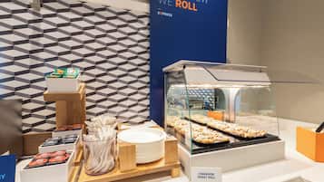Um buffet de café da manhã com diversas opções de alimentos, incluindo uma variedade de cinnamon rolls.