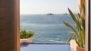 Vista de um terraço de madeira com vista para o mar, com uma pequena ilha visível ao longe.
