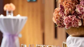 Uma mesa com taças de champanhe e um arranjo floral grande.
