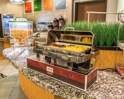 Disposição de buffet com diversos alimentos e um letreiro que diz 'YOUR morning sizzle'.