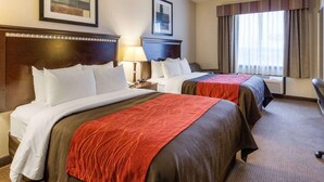 Quarto de hotel com duas camas, uma janela grande com cortinas e um quadro emoldurado na parede.