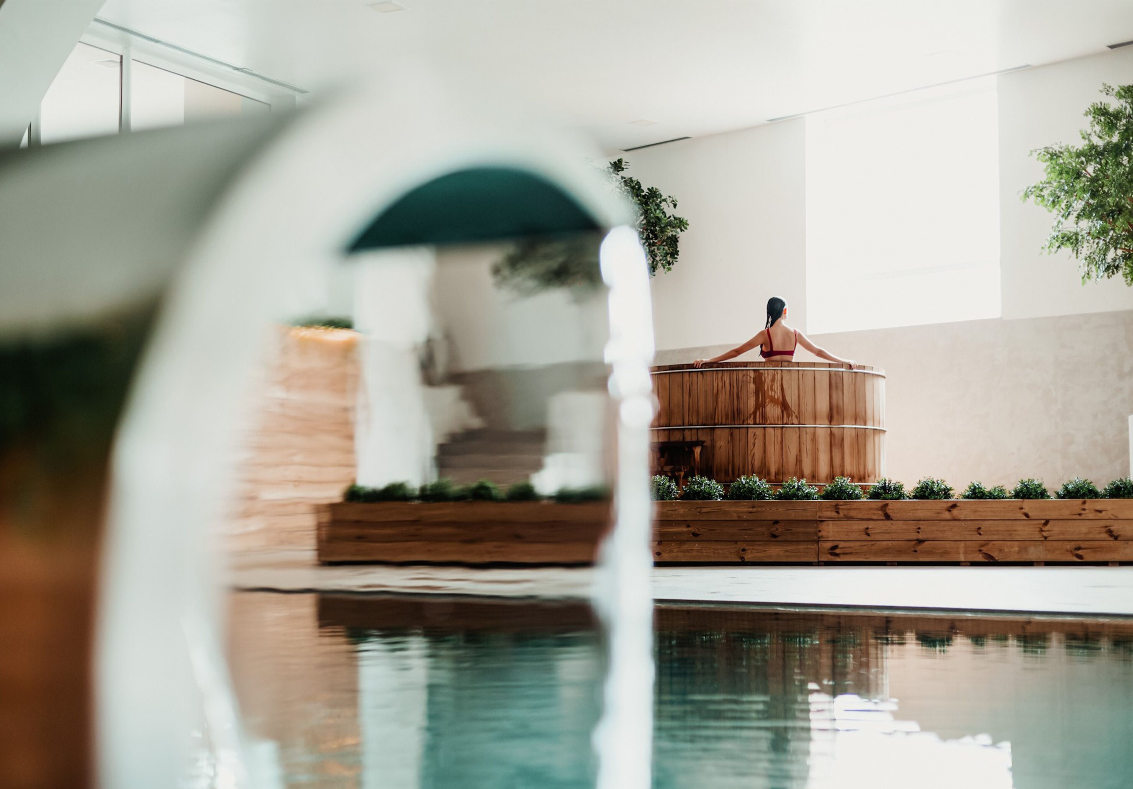 Uma área de spa com estrutura de madeira, piscina e vista para o exterior.