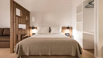 Um quarto com cama, divisória de madeira, mesa de cabeceira e guarda-roupa.