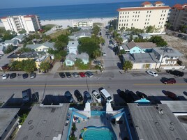Um hotel com piscina, vários espaços de estacionamento e vista para a praia.