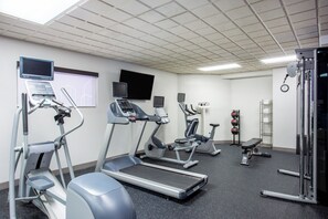 Academia com esteiras, elípticos e equipamentos de musculação.