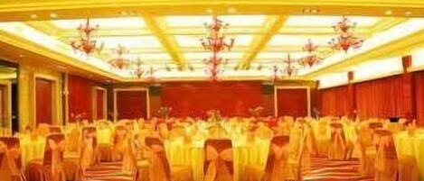 Uma sala de baile com fileiras de cadeiras e um palco.
