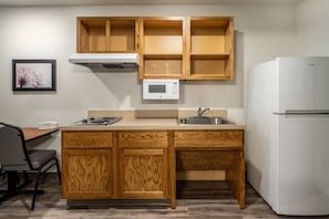 Um frigorífico/congelador grande, um micro-ondas, uma placa de cozinha 