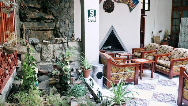 Uma sala de estar acolhedora, com lareira, assentos confortáveis e parede de pedra.
