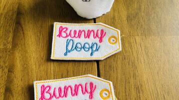 Um brinquedo de pelúcia com corpo branco e orelhas cor-de-rosa, e duas etiquetas com o texto "Bunny Loop".