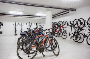 Espaço para guardar bicicletas com várias bicicletas estacionadas na parede.