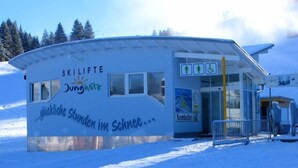 Estação de teleférico chamada 'SKILIFTE Jungfrau' com sinalização indicando instalações acessíveis.