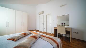 Quarto com cama, escrivaninha e guarda-roupa.
