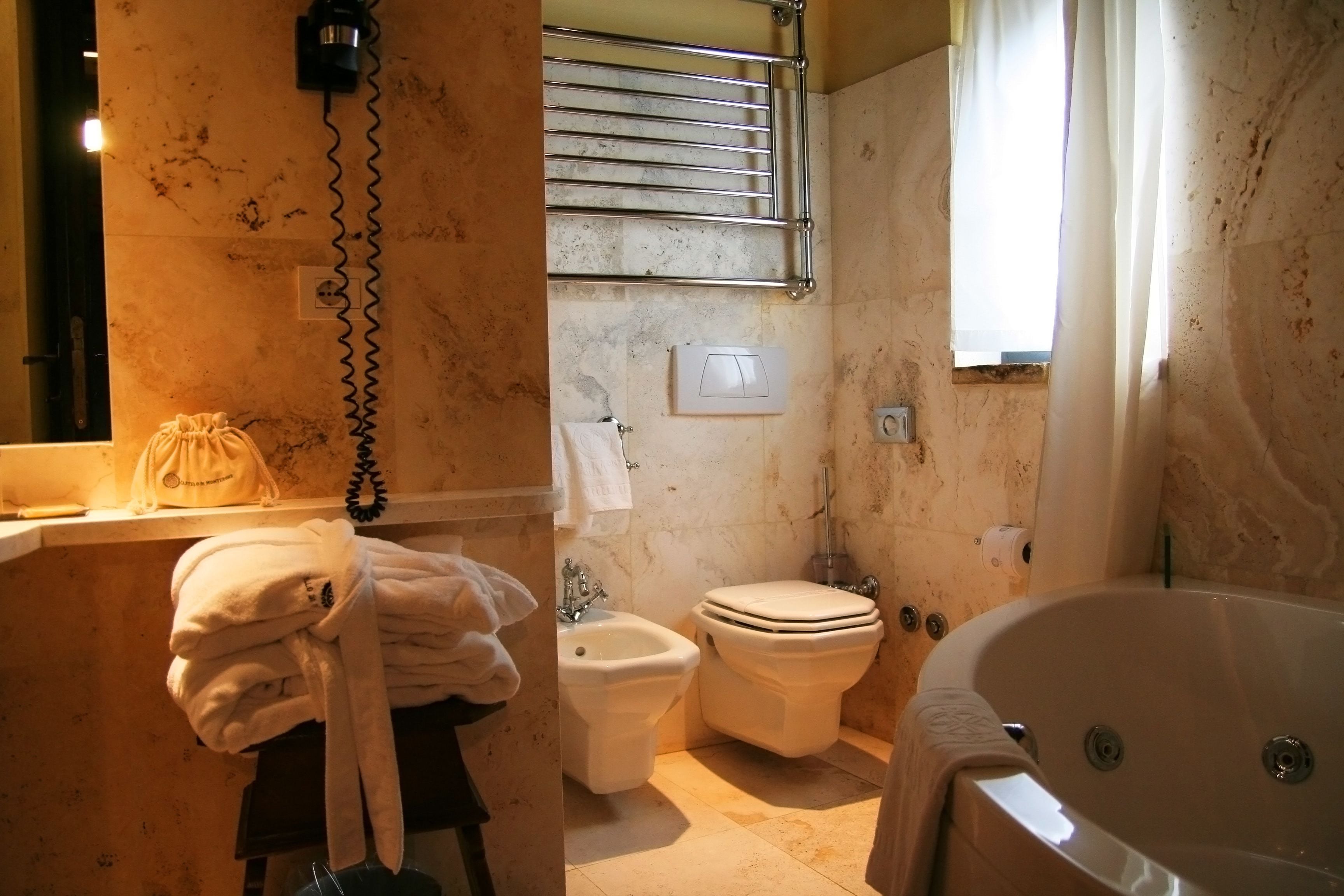 Casa de banho com banheira, sanita, bidé e toalheiro com toalhas.