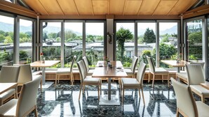 Restaurante com vista para uma paisagem montanhosa através de amplas janelas.