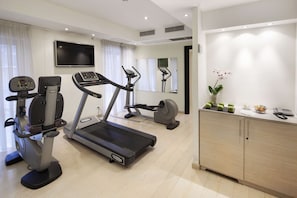 Uma academia moderna para casa, com esteira, bicicleta ergométrica e elíptico.