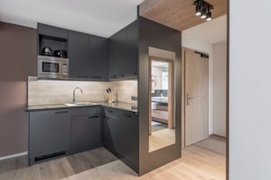 Suíte, 1 quarto, cozinha americana | Cozinha privada | Geladeira grande, micro-ondas, cooktop, lava-louças