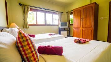 Quarto de hotel com duas camas, uma televisão em um suporte e um guarda-roupa.