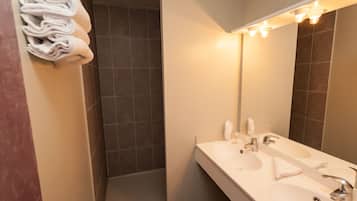 Uma casa de banho moderna com uma sanita dupla, um espelho grande e um porta-toalhas.