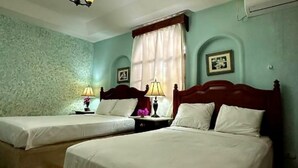 Quarto com duas camas de solteiro, cada uma com cabeceira de madeira, mesa de cabeceira com abajur e janela com cortina.
