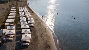 Na praia, barracas de praia de cortesia, espreguiçadeiras, guarda-sóis 