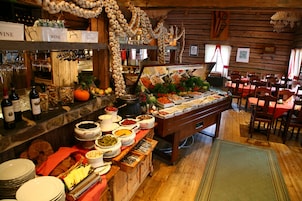 Uma mesa de buffet com diversos alimentos e garrafas de vinho.