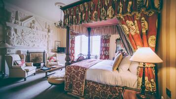Um quarto tradicional com cama de dossel, lareira e decoração clássica.