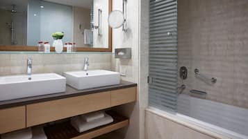 Uma casa de banho moderna com duas bacias, um espelho grande e cabine de duche com vidro.