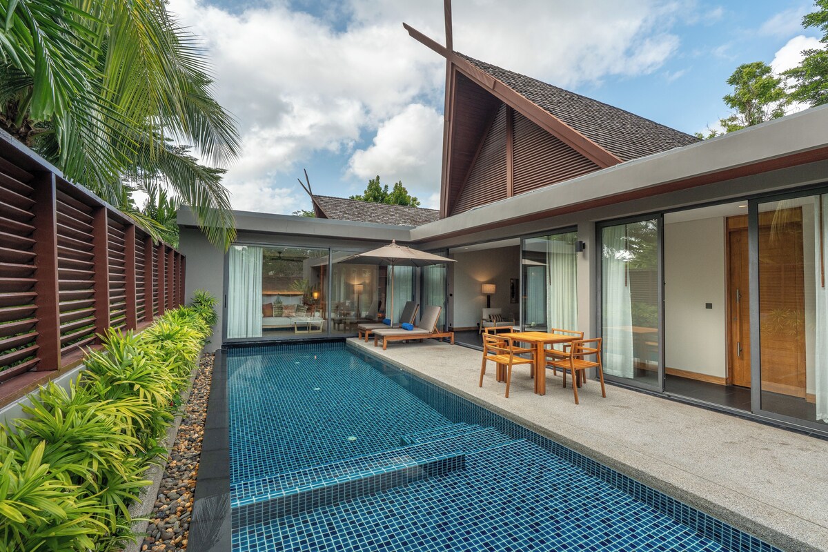 Uma casa moderna com piscina, área de estar externa e uma grande porta de vidro.