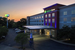 Edifício Holiday Inn Express com estacionamento e entrada coberta.
