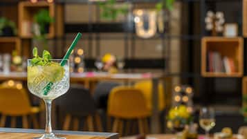 Um copo de cocktail com canudo sobre uma mesa de madeira em um restaurante.