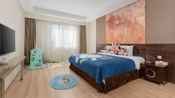 Quarto de hotel com cama, televisão, escrivaninha, abajur, cadeira, janela com cortinas e um quadro abstrato grande na parede.